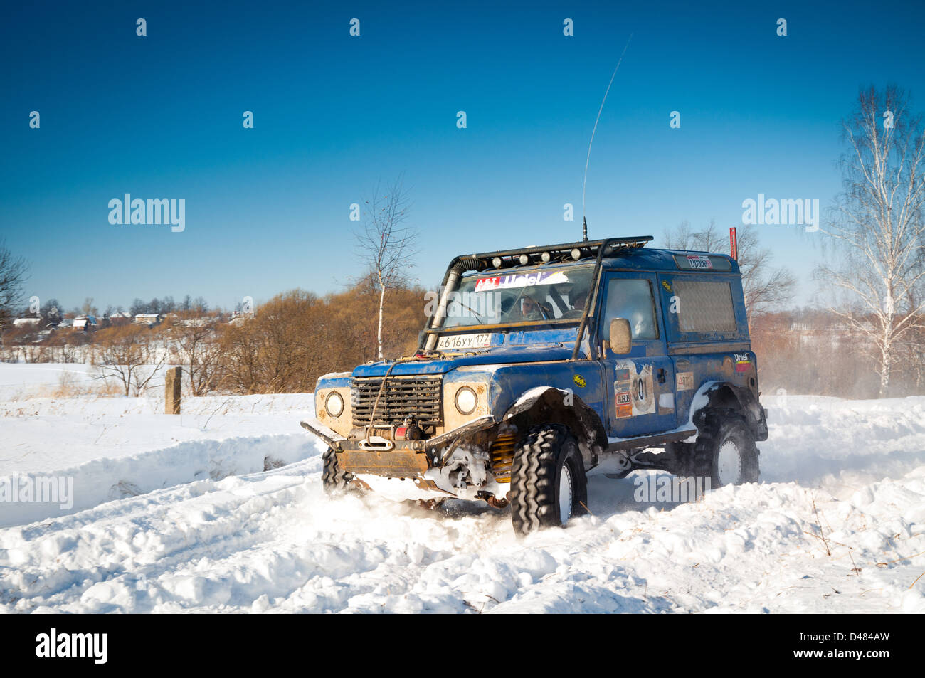 Blue Land Rover Defender 90 suv front on background the Russian winter ...
