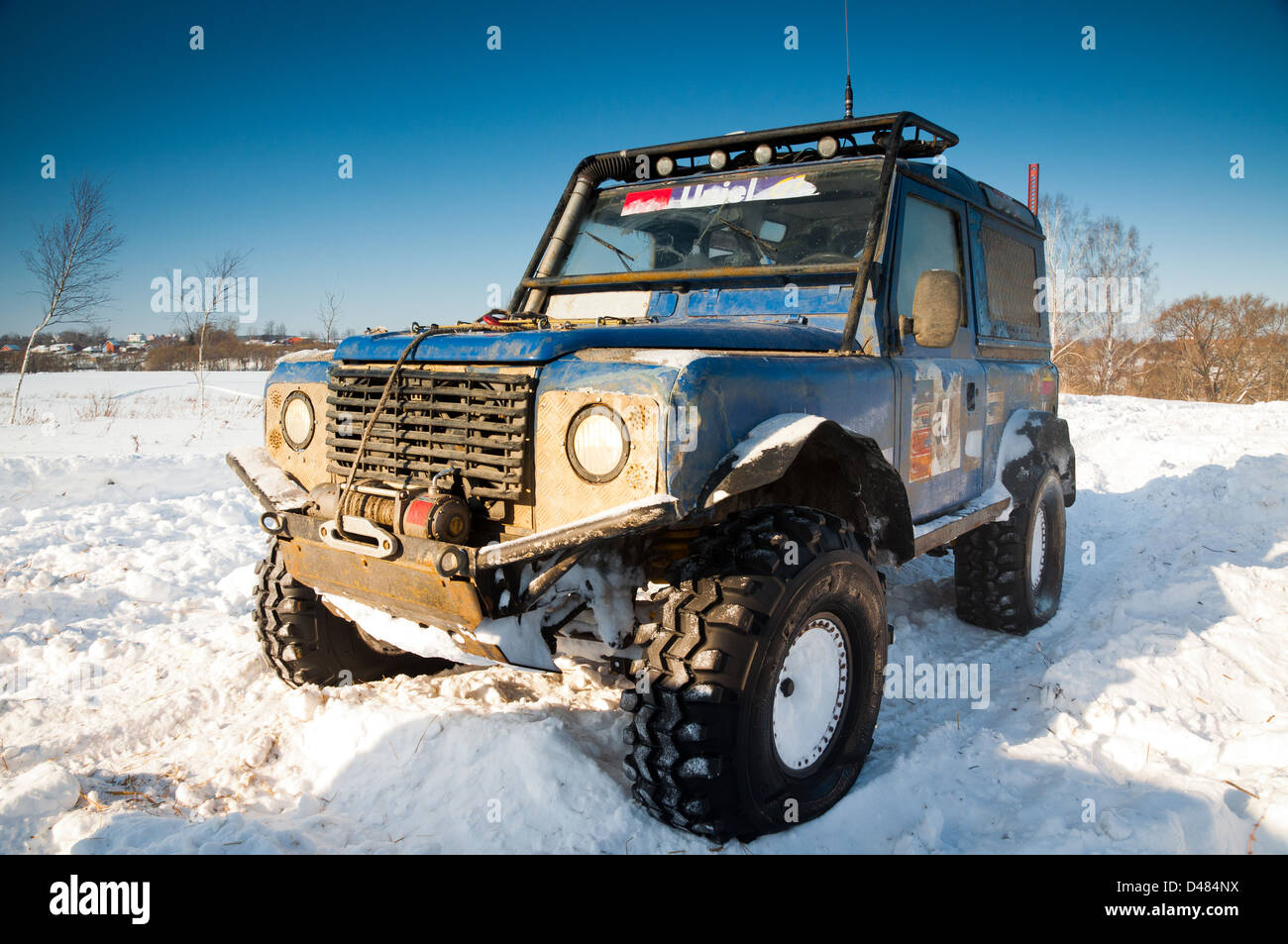 Blue Land Rover Defender 90 suv front on background the Russian winter ...