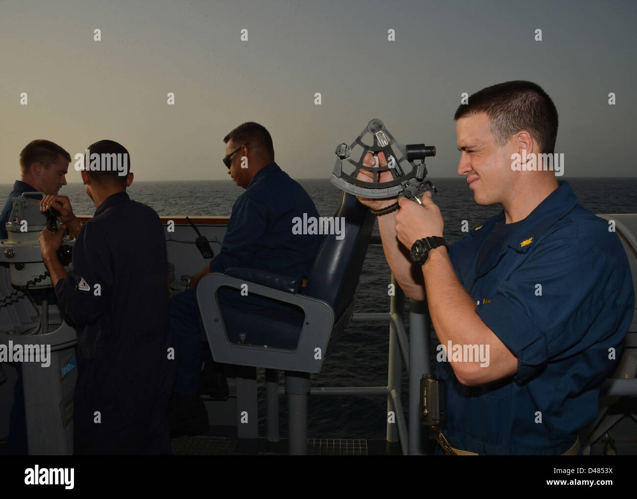 A U.S. Navy officer uses a sextant aboard the USS Halyburton (FFG 40 ...