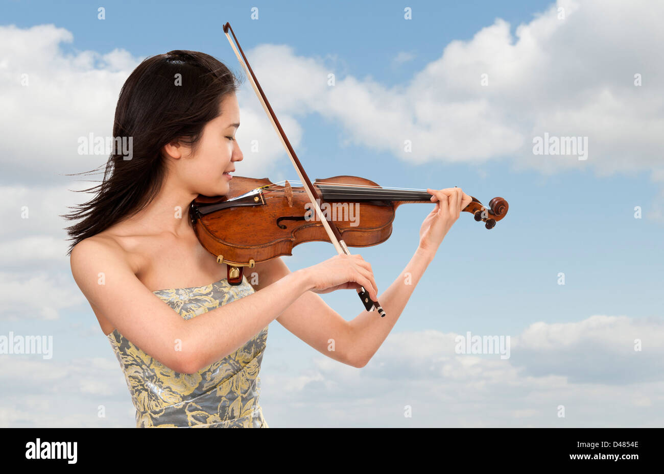 young asian woman playing the violin outdoors, clouds background Stock ...