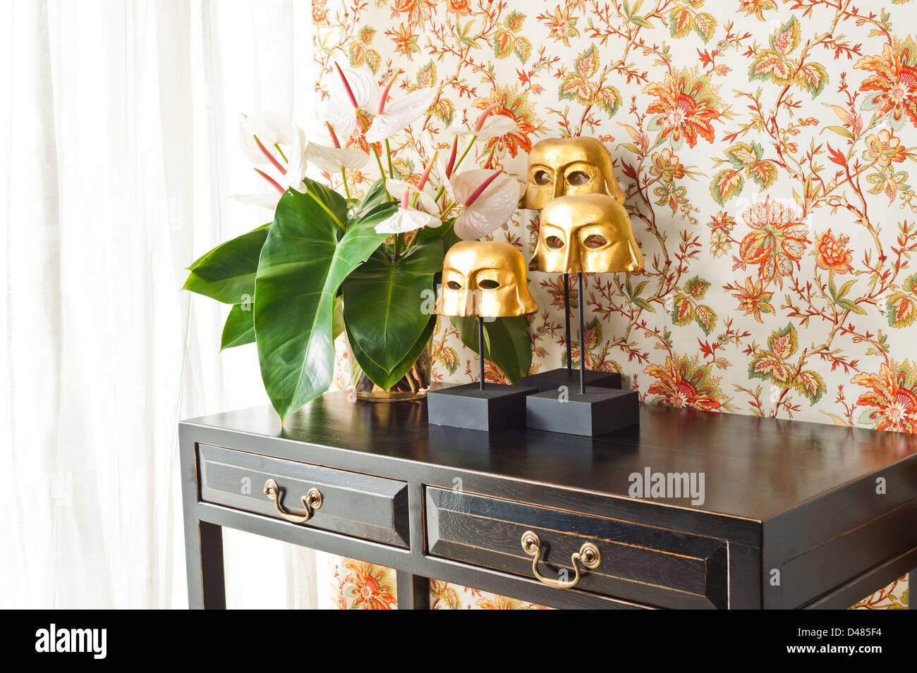 Side table with flowers and interior decoration next to bright window ...