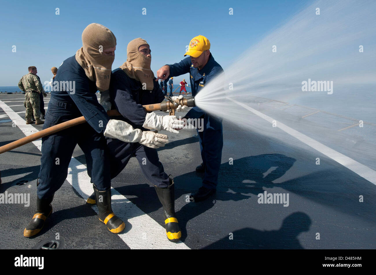 Sailors aboard a U.S. Navy vessel conduct firefighting training in the ...