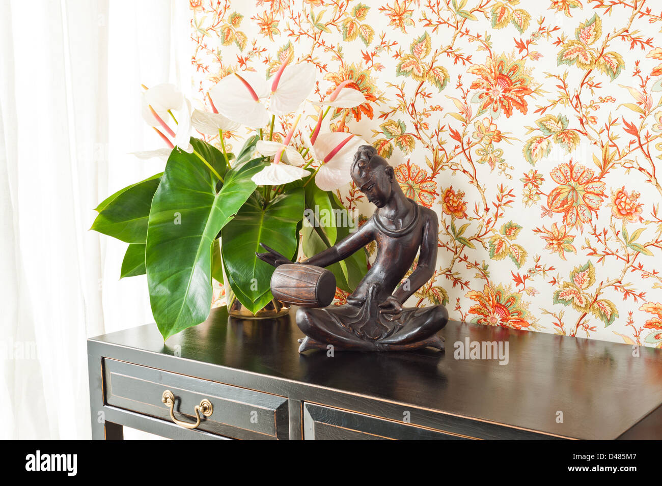 Side table with flowers and interior decoration next to bright window ...
