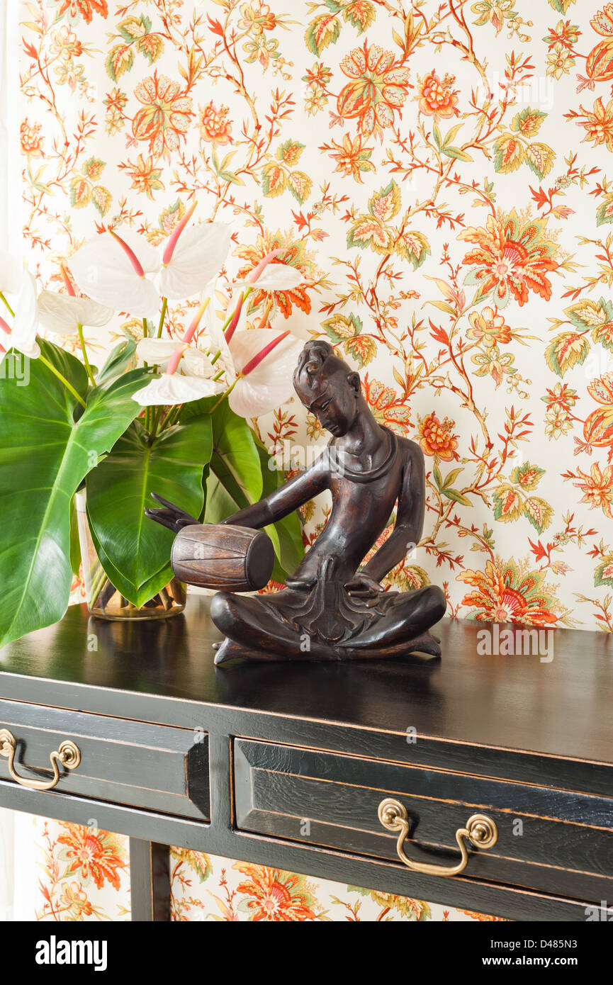 Side table with flowers and interior decoration next to bright window ...