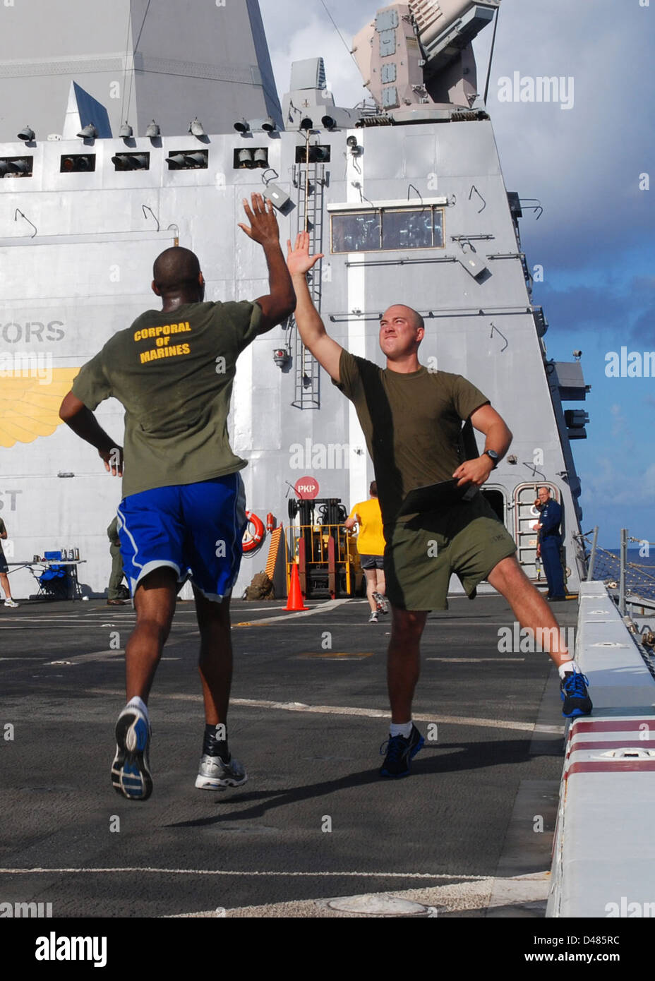 Two Marines celebrate after completing a 5k run aboard a naval vessel ...