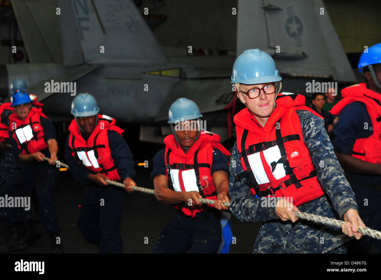 Sailors aboard a U.S. Navy ship heave a line during a replenishment at ...