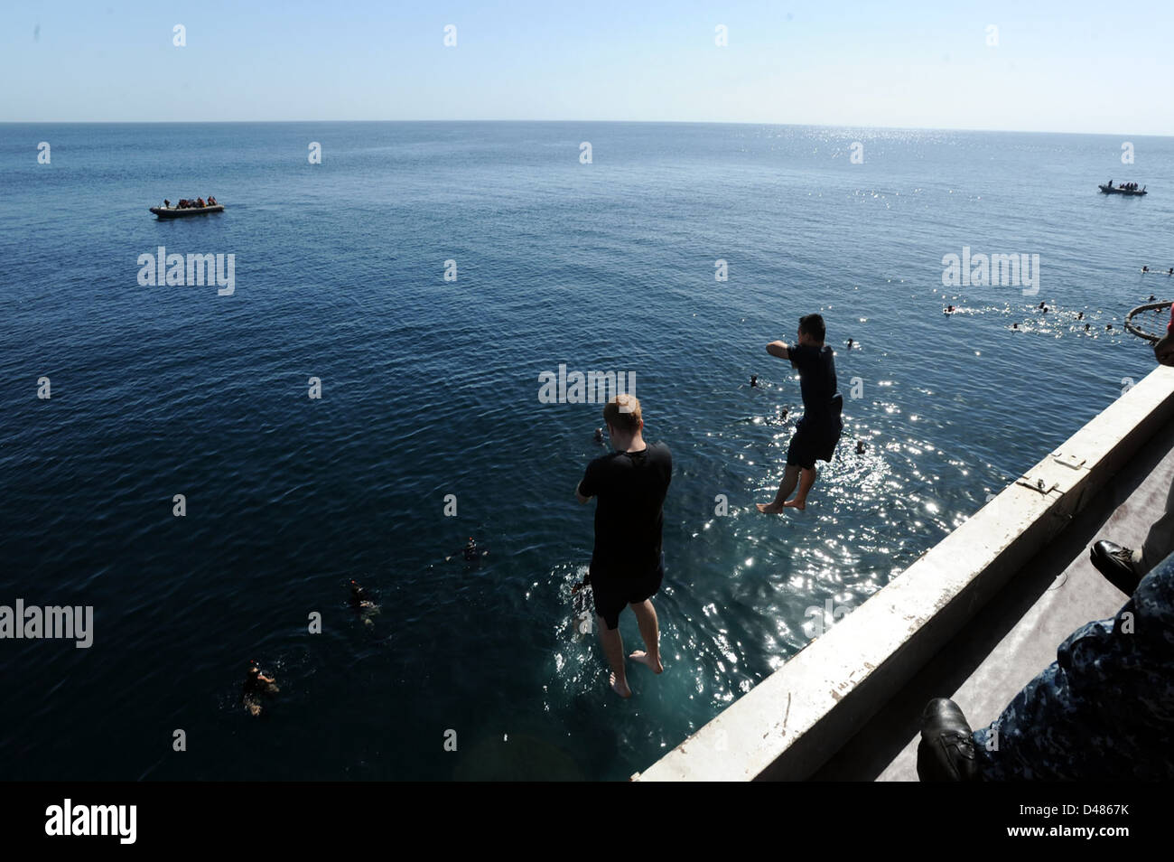 Sailors participate in a swim call in the Arabian Sea, taking a break ...