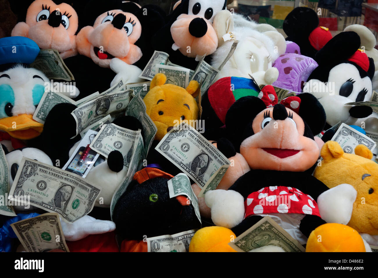Puppets with Dollar bills in a claw crane arcade game grabbing machine ...