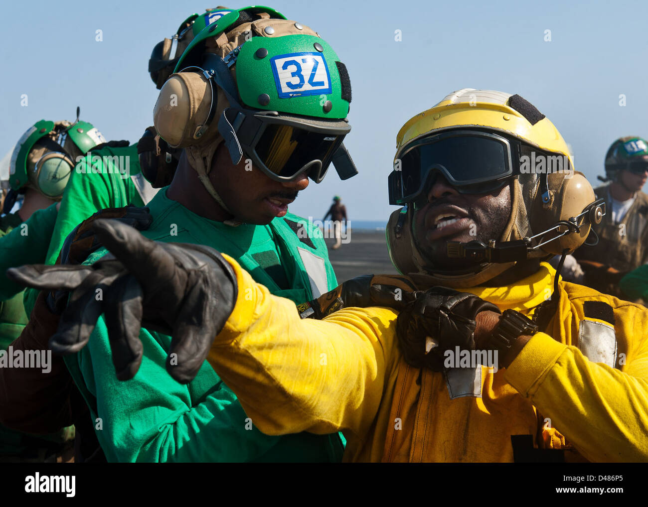 A Sailor directs fire fighters during a drill in the Red Sea, focusing ...