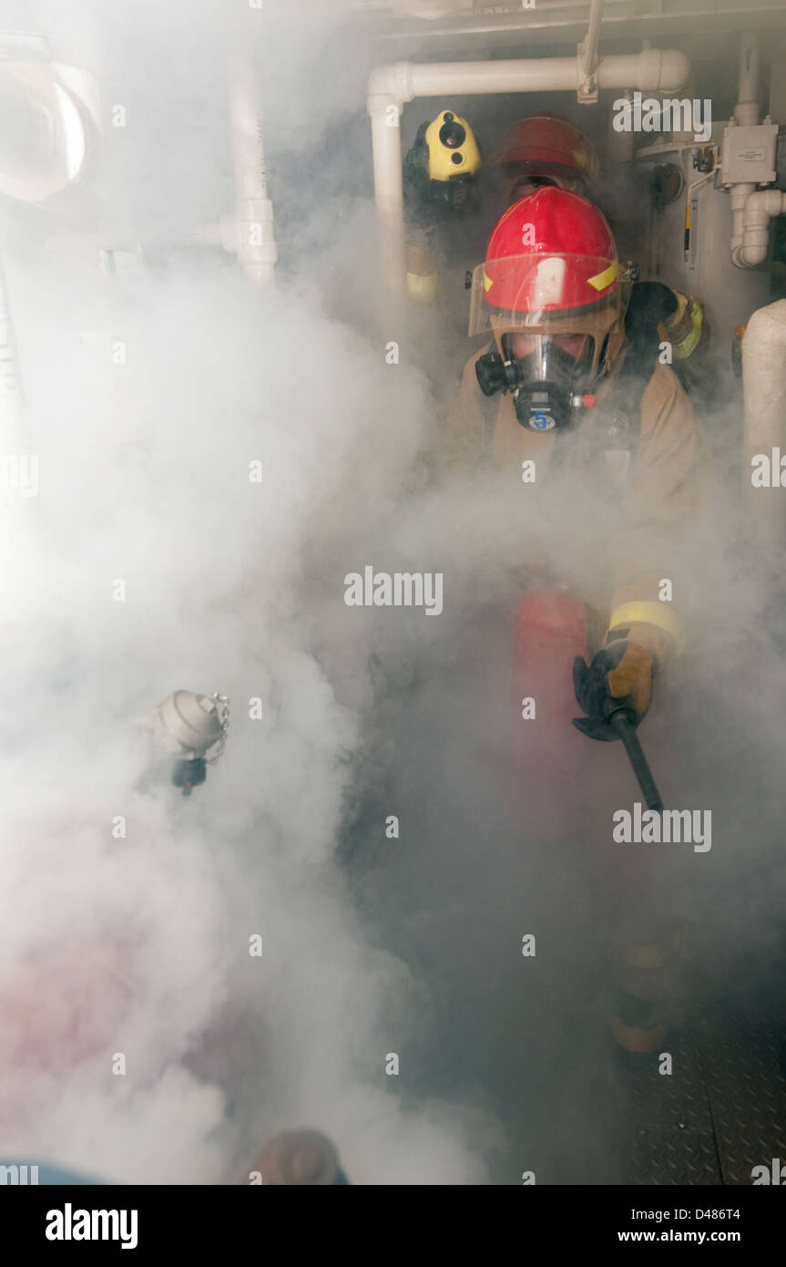 A U.S. Navy Sailor enters a smoke-filled space during firefighting ...