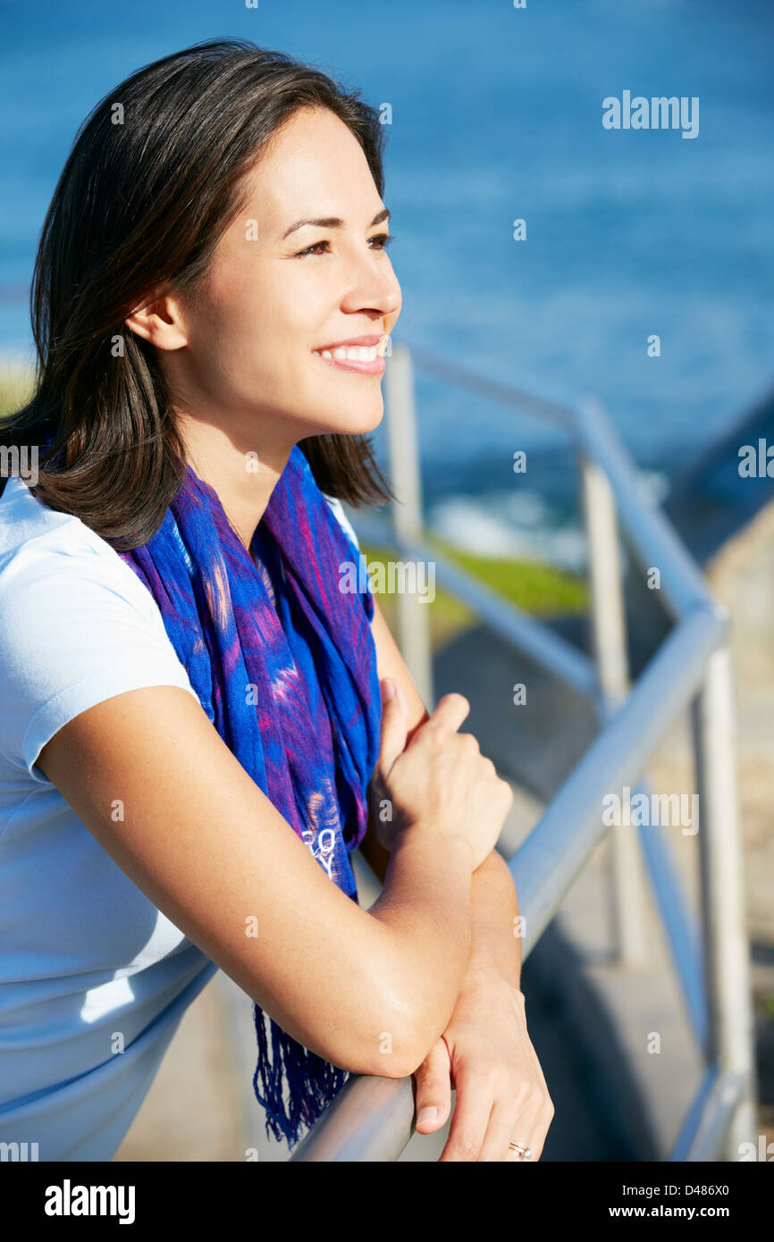 Hispanic Woman Looking Over Railing At Sea Stock Photo - Alamy