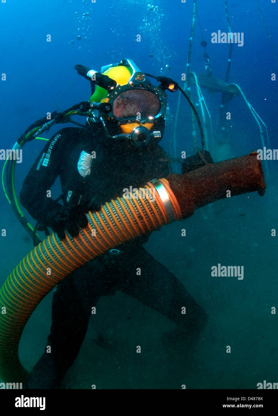 A U.S. Navy diver operates a suction dredge in the Mediterranean Sea ...