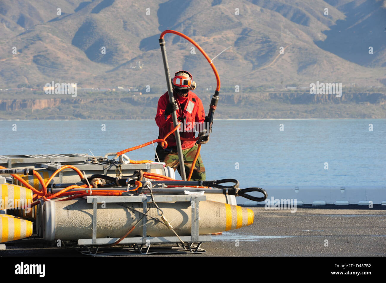 A Sailor moves a cargo hook aboard a naval vessel in the Pacific Ocean ...