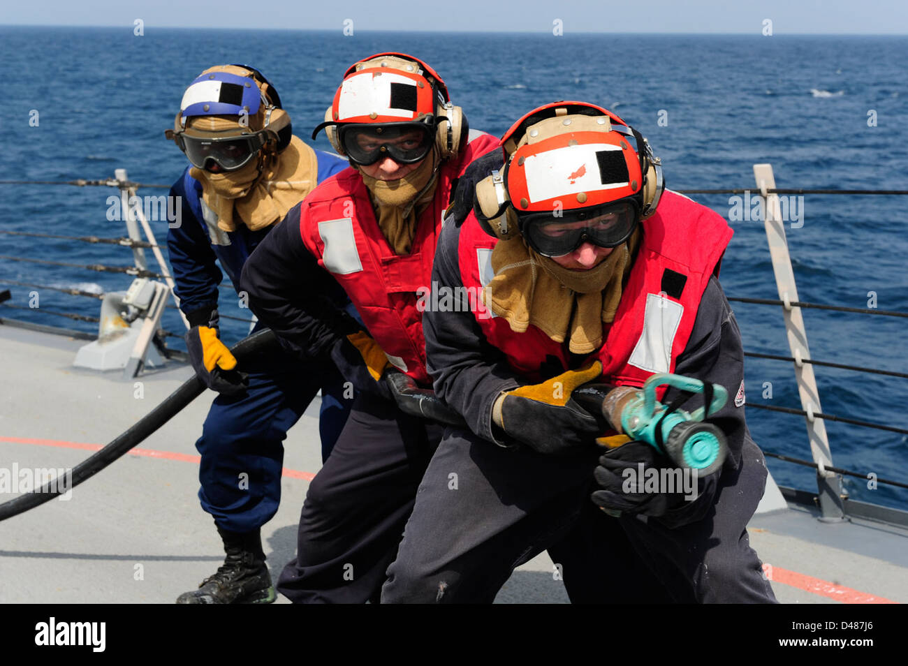 U.S. Navy sailors engage in a simulated fire-fighting exercise aboard a ...