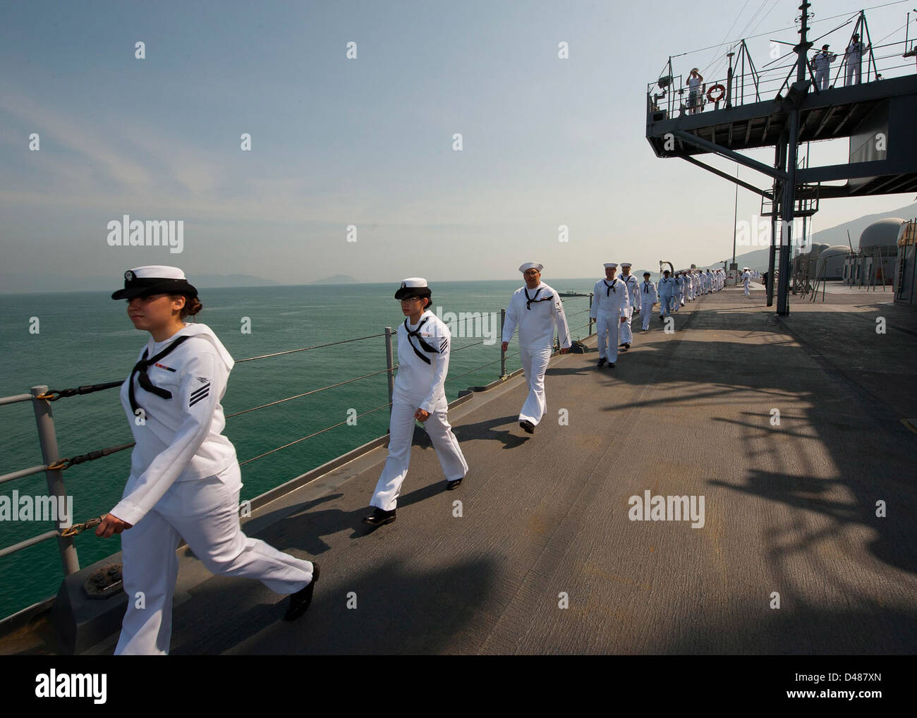 Sailors aboard a U.S. Navy ship prepare to man the rails during a ...