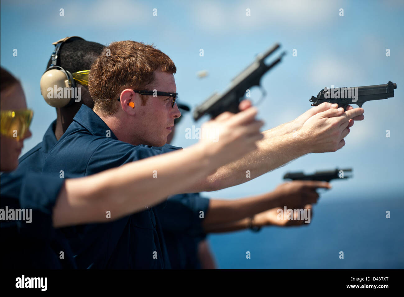 A U.S. Navy Sailor aims his 9mm pistol during a training session ...
