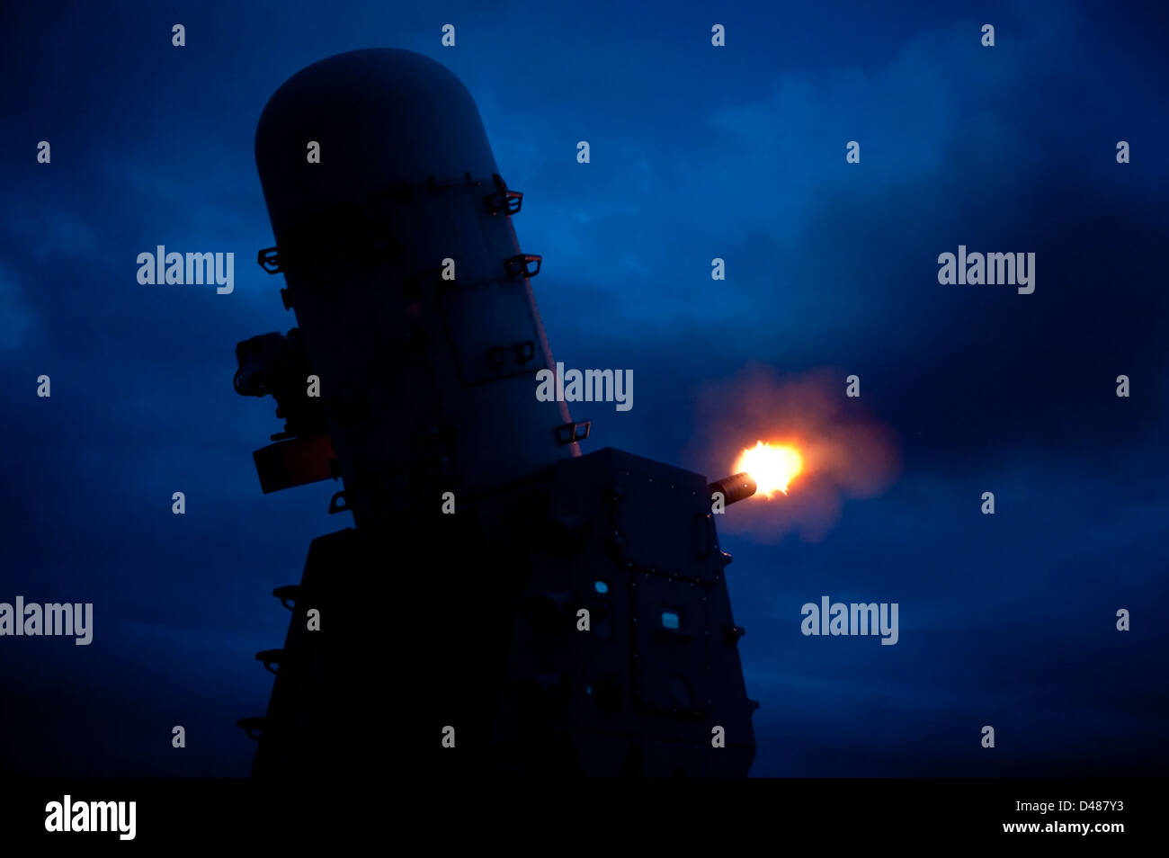A CIWS mount fires at night Stock Photo - Alamy