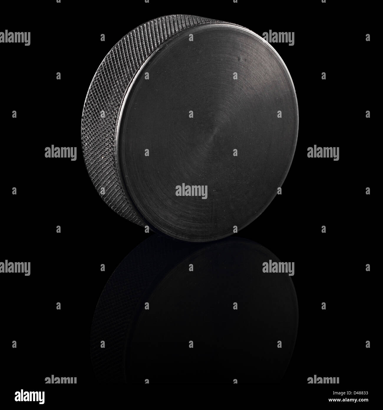 ice hockey puck in front of black background Stock Photo - Alamy