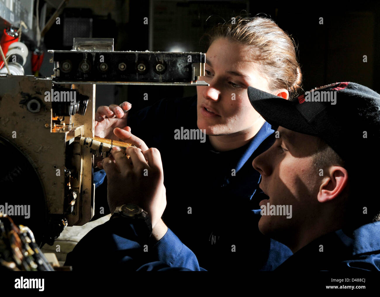 Sailors aboard a U.S. Navy ship perform maintenance on an electric ...