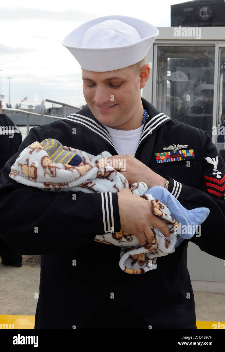 A U.S. Navy Sailor holds his newborn child for the first time after ...