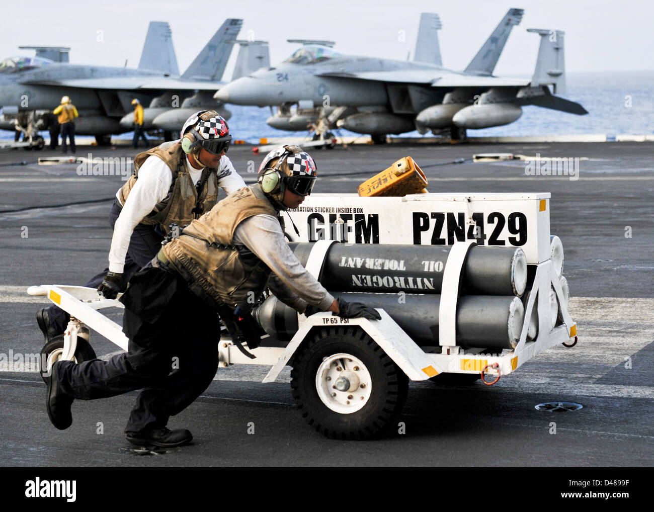 Sailors move a nitrogen cart aboard a U.S. Navy ship in the Pacific ...