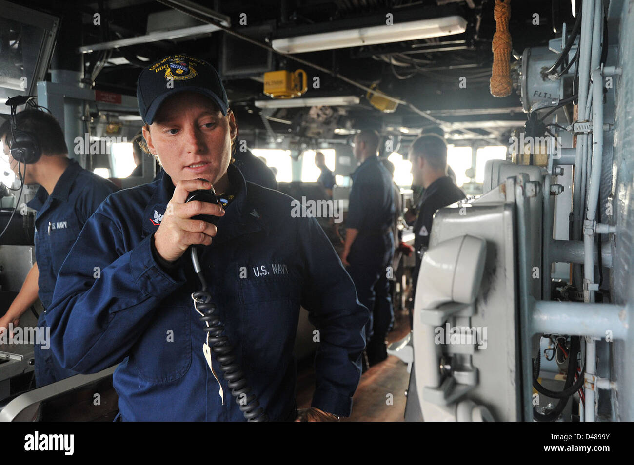 A U.S. Navy Sailor makes an announcement to the crew aboard a ship ...