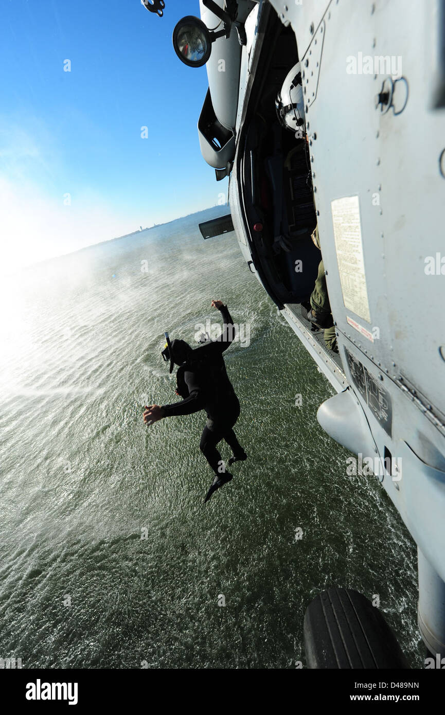 A U.S. Navy Sailor performs a jump from an MH-60S Seahawk helicopter ...