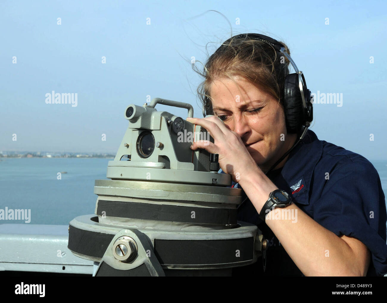 A sailor aboard USS New York takes a bearing while navigating through ...