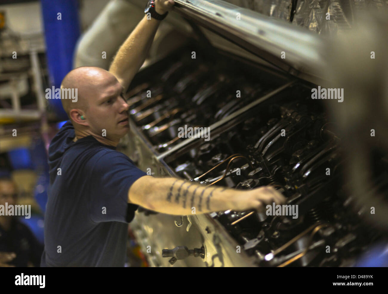 A Sailor inspects a generator aboard a U.S. Navy ship in the Arabian ...