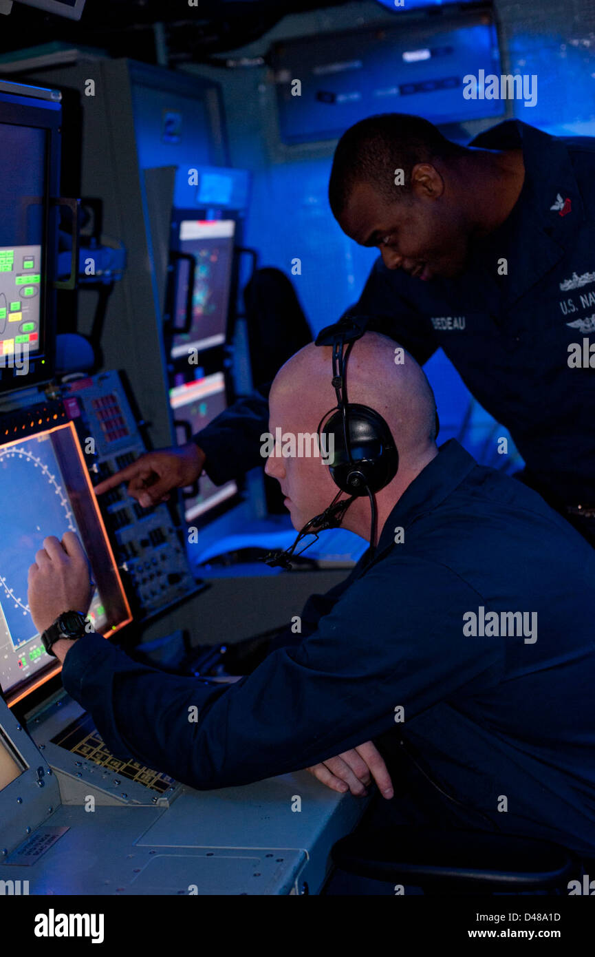 Sailors aboard a U.S. Navy vessel monitor for submarines in the ...