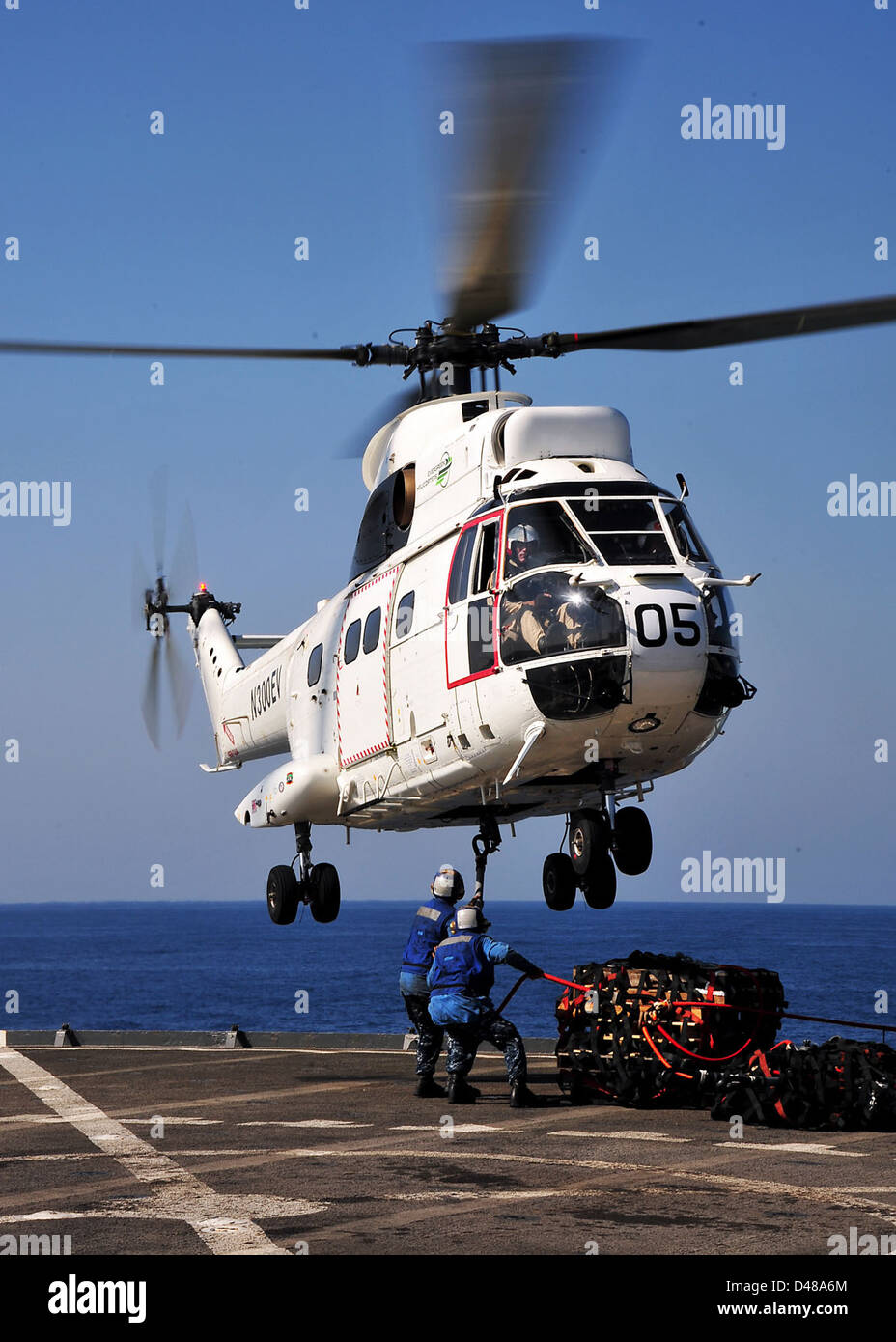 Sailors prepare cargo for air transport using an AS 332 helicopter in ...
