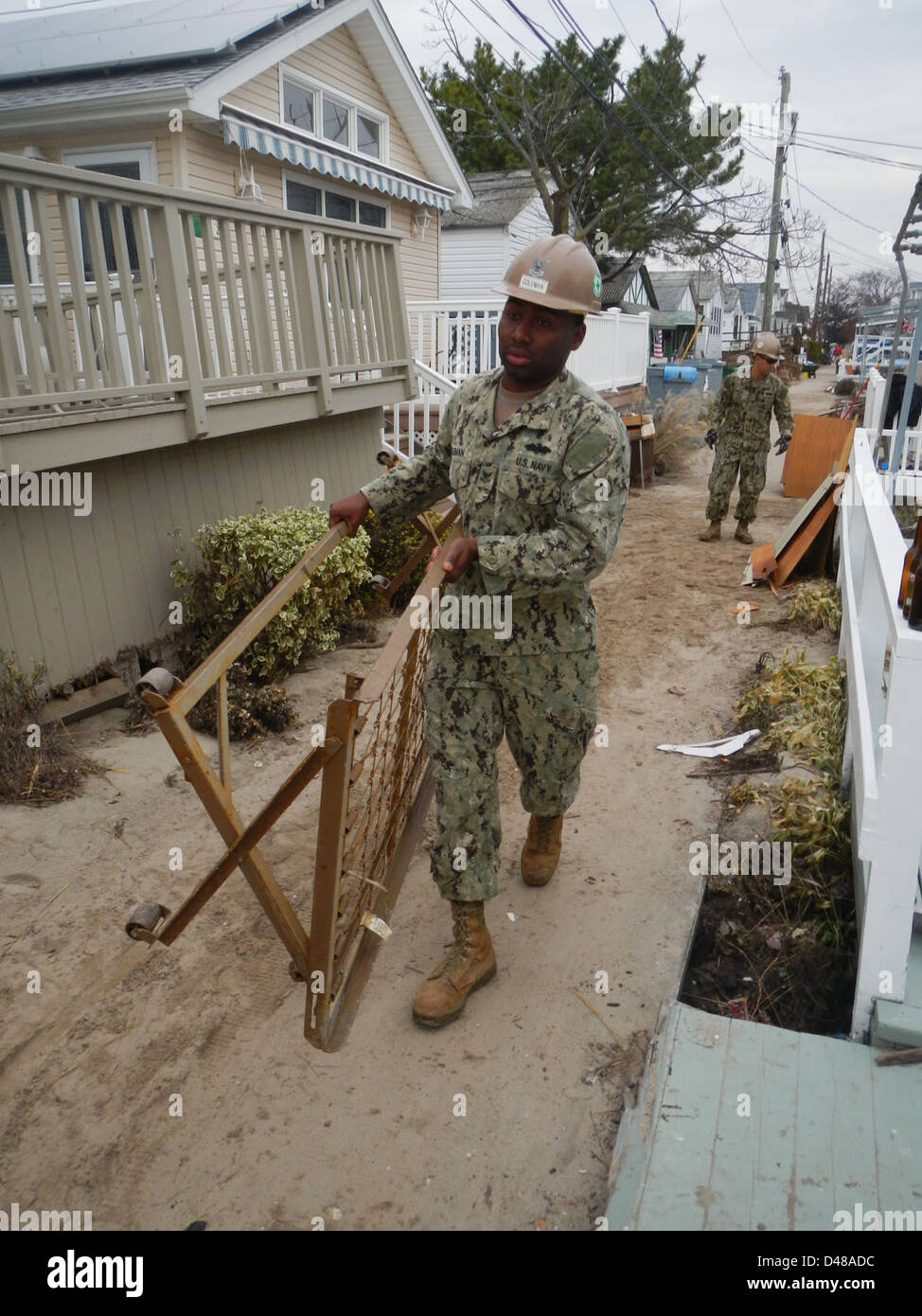 A Seabee from the U.S. Navy assists in debris removal operations in ...