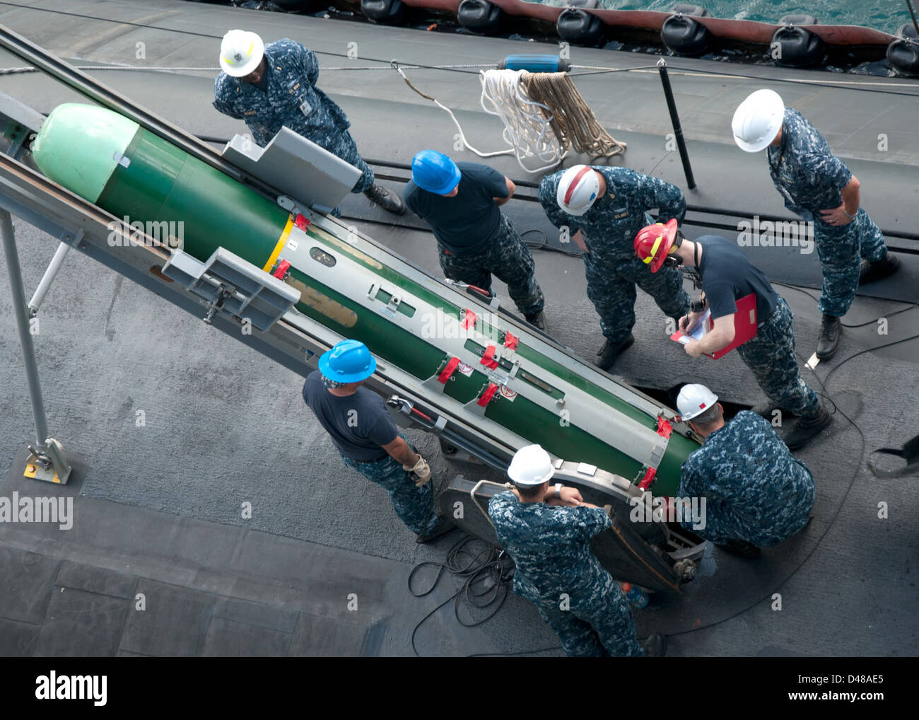 Sailors aboard USS Oklahoma City (SSN 723) remove a torpedo from the ...