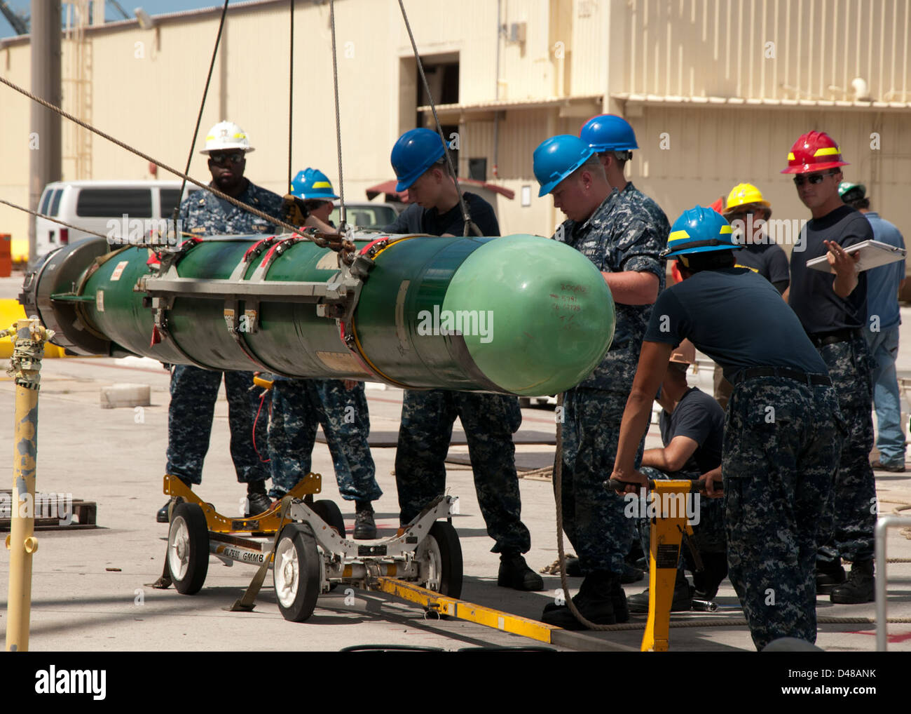 Sailors lower a torpedo to the pier Stock Photo - Alamy