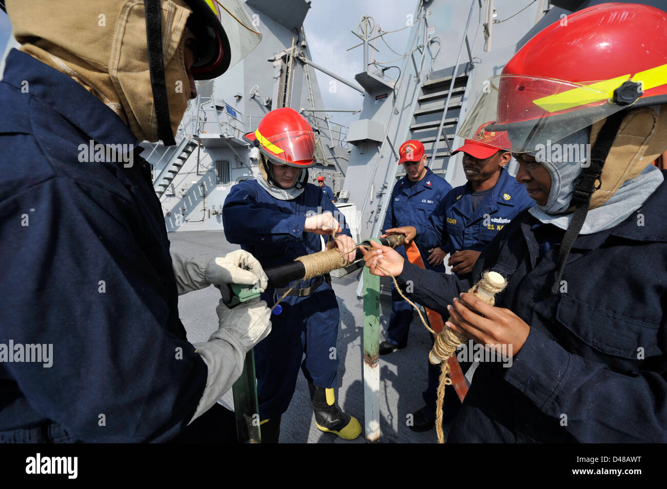 Sailors aboard a Navy vessel in the Arabian Sea practice pipe patching ...