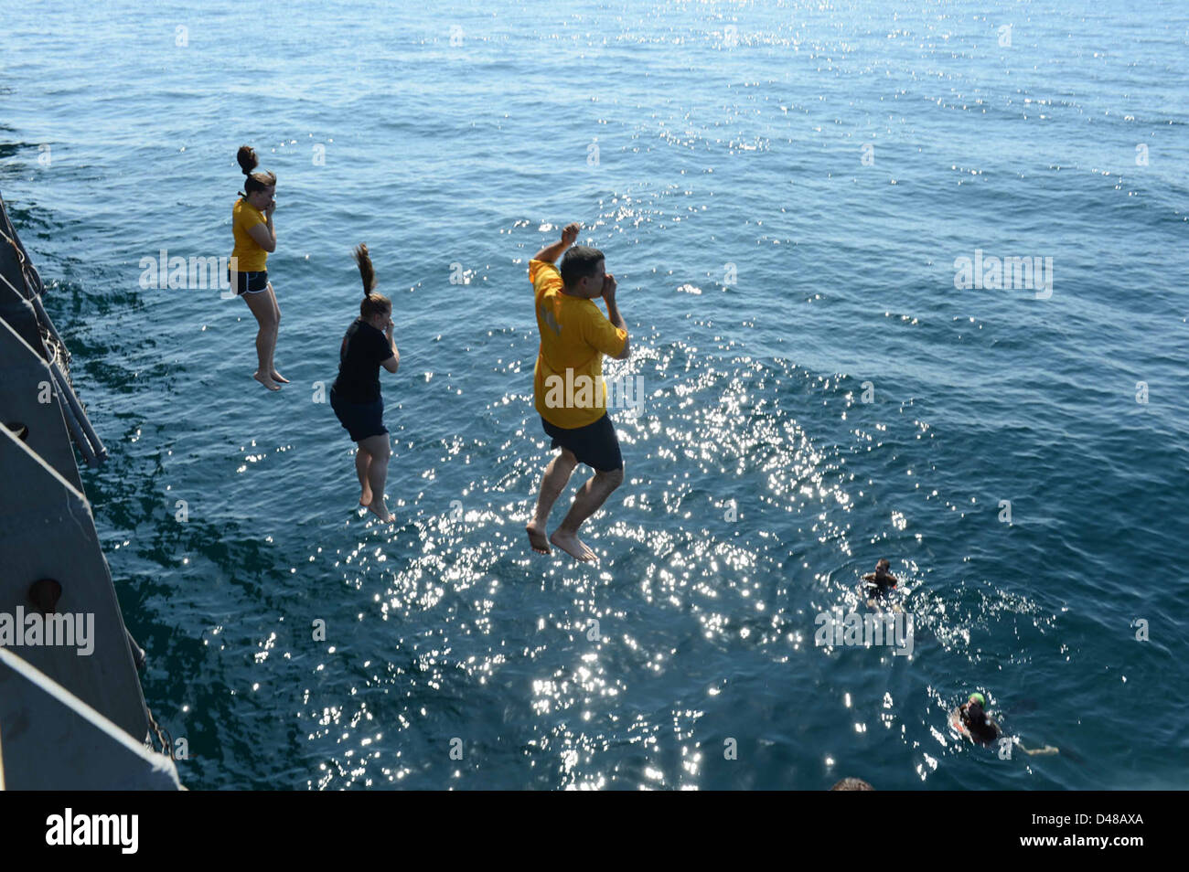 Sailors participate in a swim call off the ship during a deployment in ...