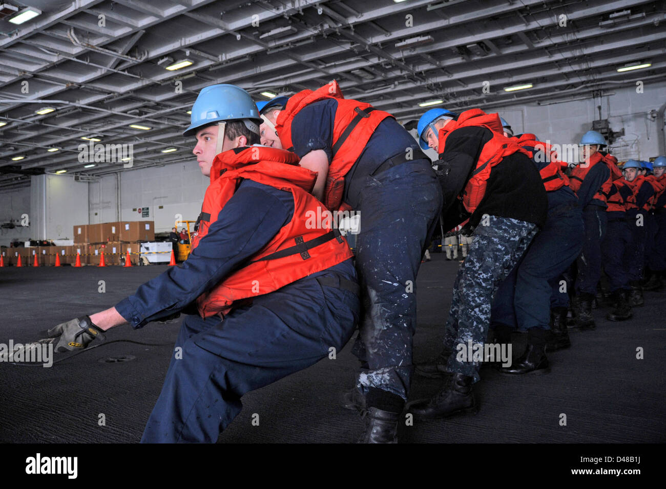 Sailors aboard a U.S. Navy vessel in the Pacific Ocean heave on a phone ...