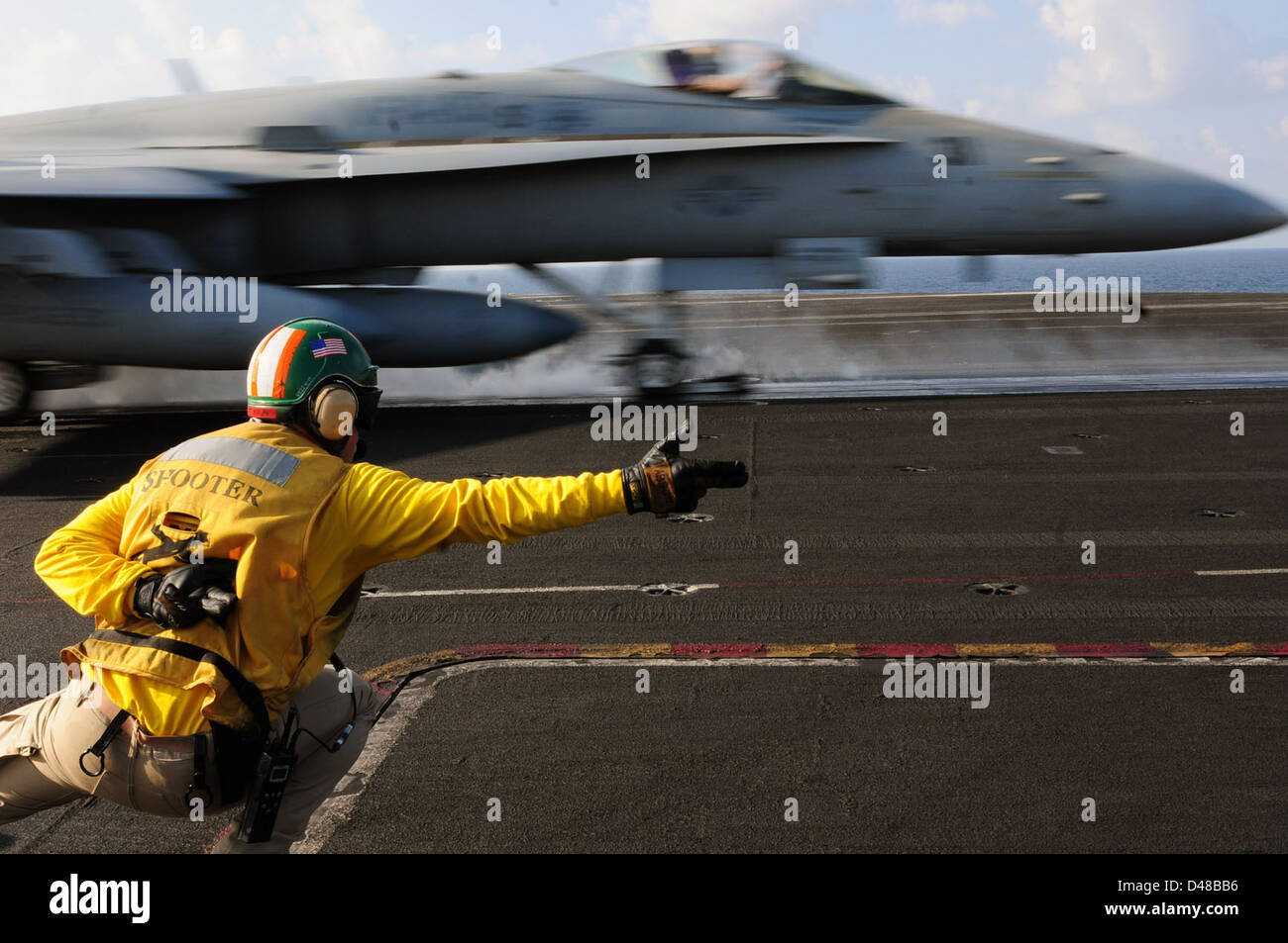 An officer launches an F/A-18C Hornet from a U.S. Navy aircraft carrier ...