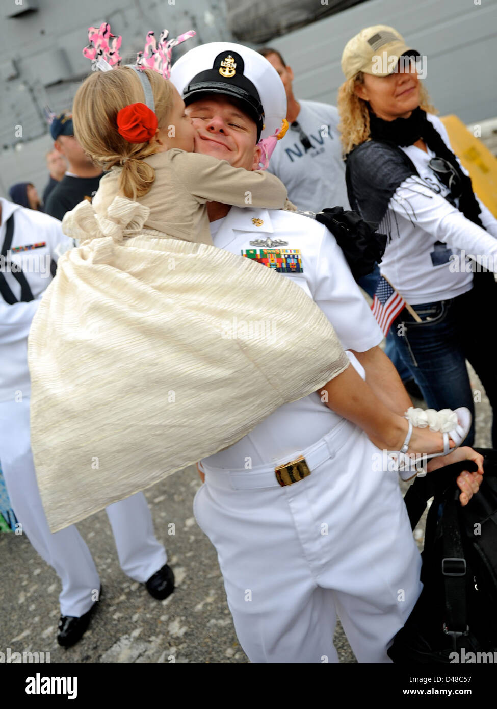 A U.S. Navy sailor embraces his daughter during a homecoming ceremony ...