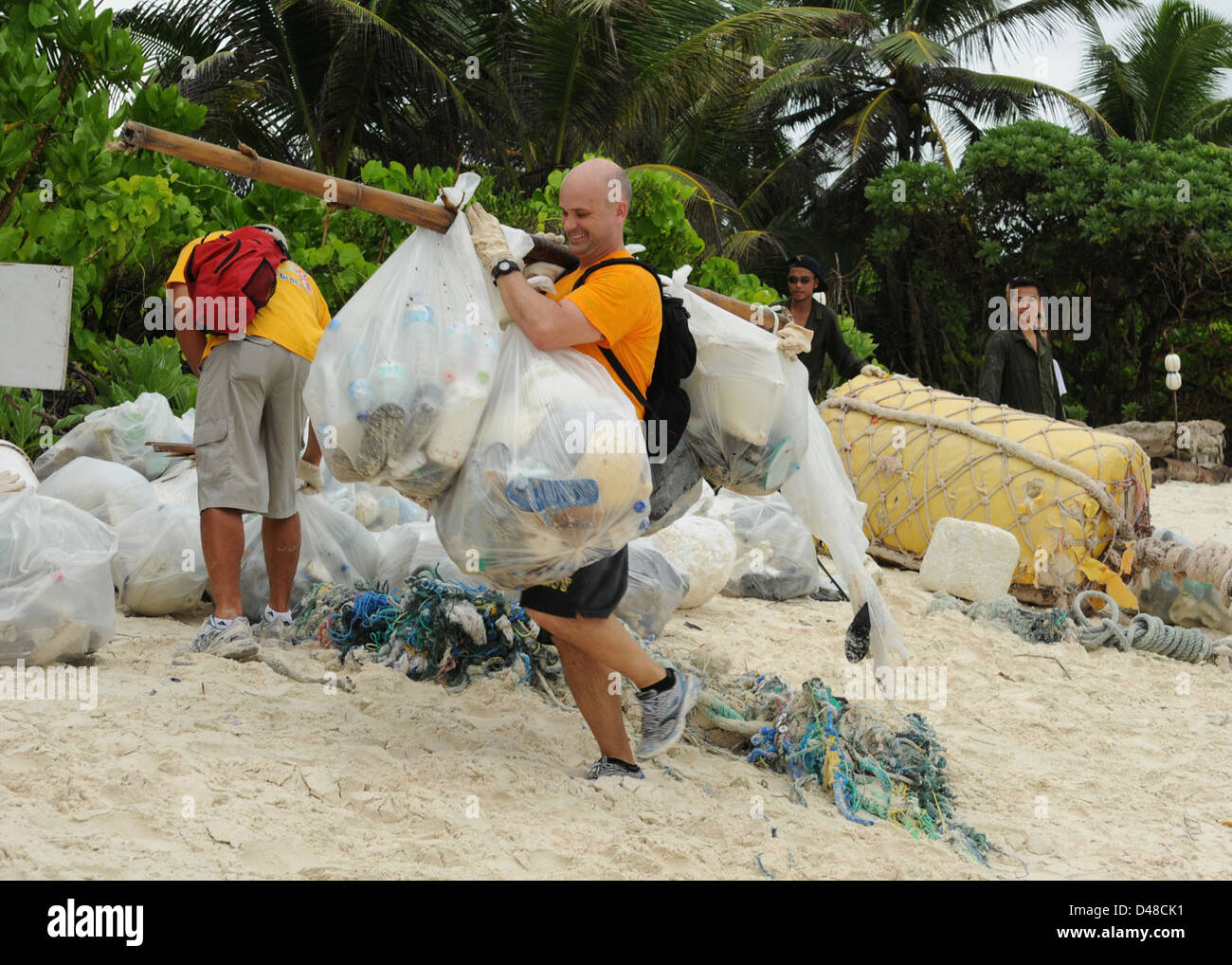 A Sailor collects trash on the beach Stock Photo - Alamy