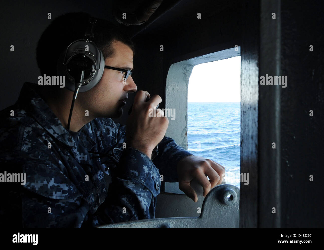 A U.S. Navy sailor stands lookout watch at sea aboard a ship in the ...