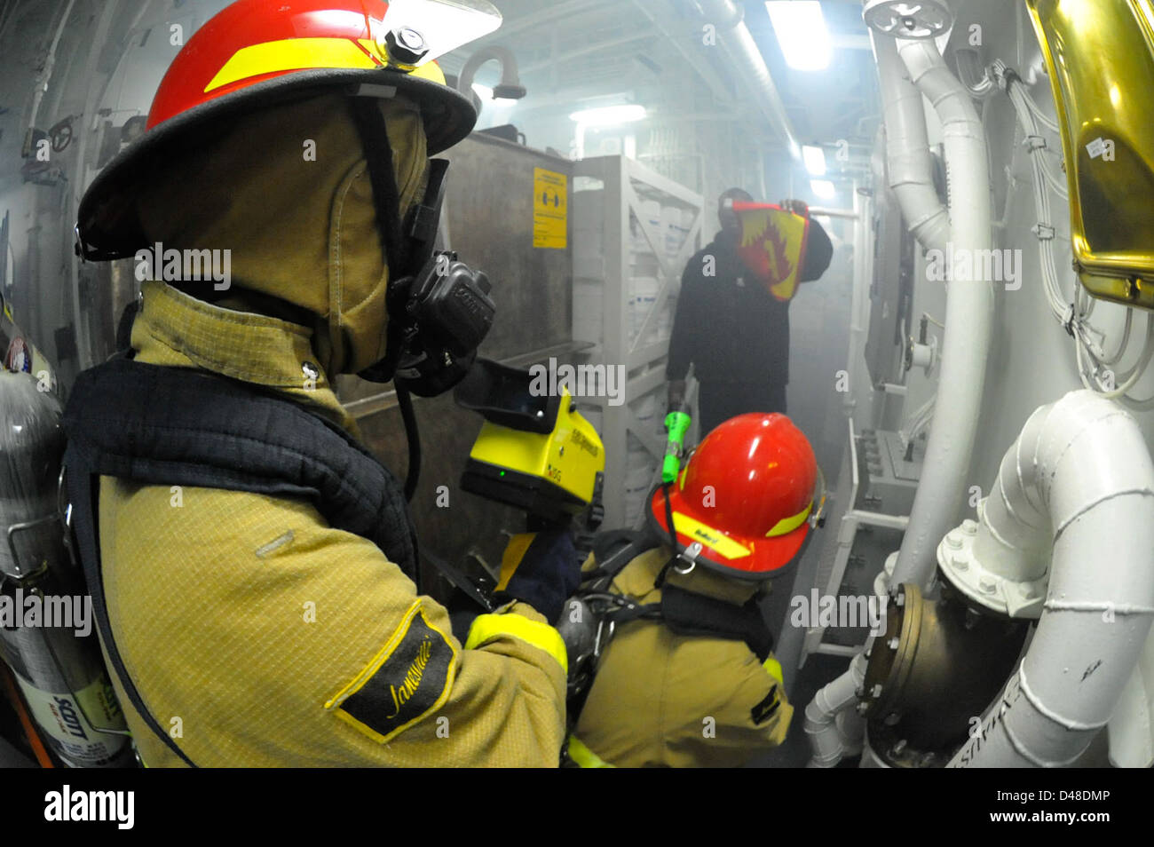 Sailors aboard a U.S. Navy ship engage in a simulated fire drill in the ...