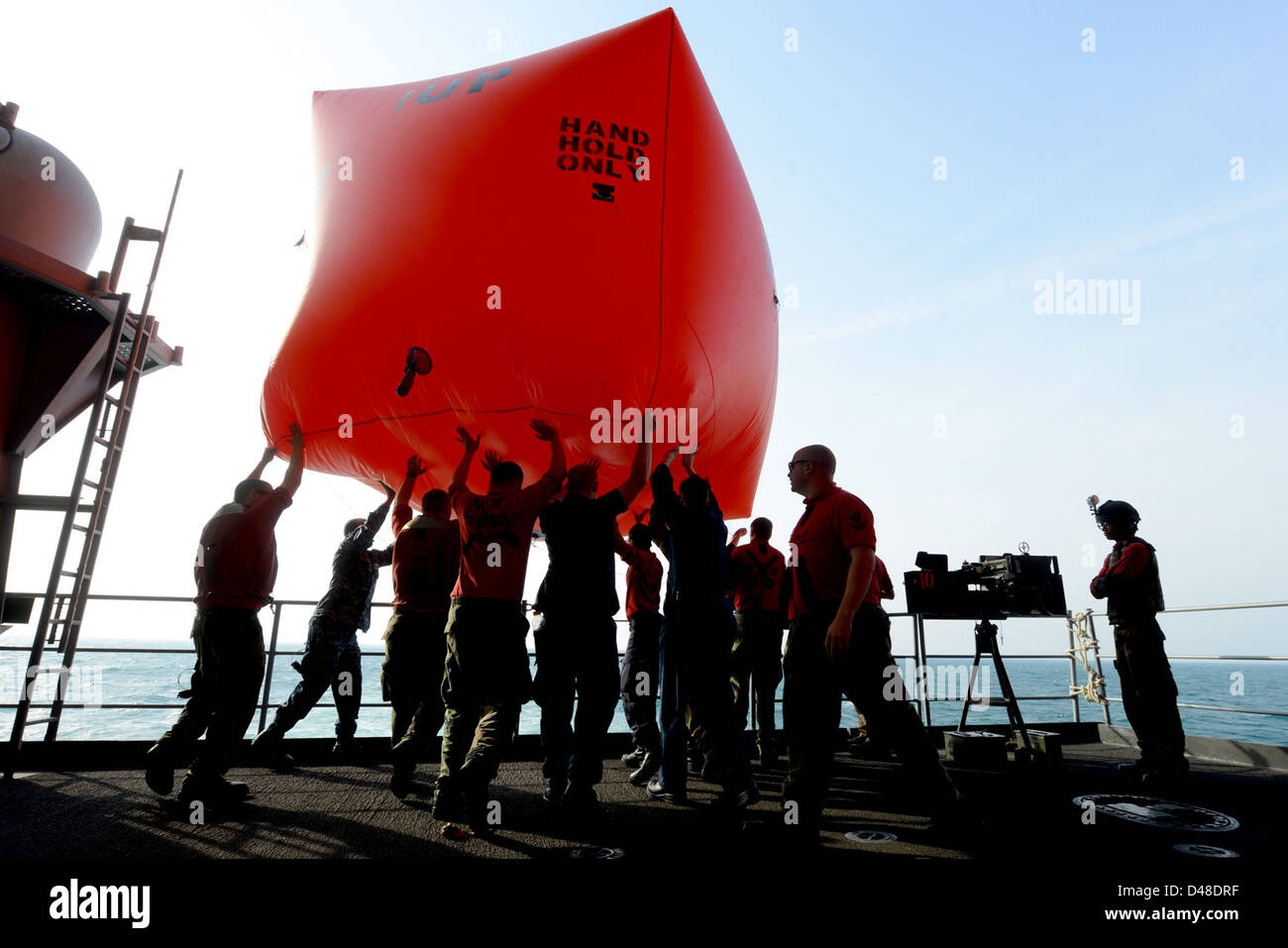 Sailors aboard a U.S. Navy ship dispose of a floating target in the ...