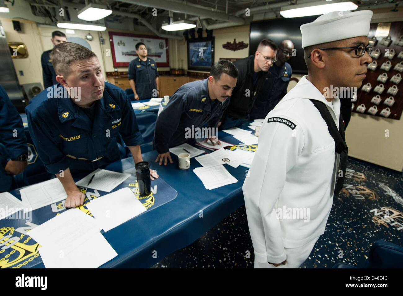 U.S. Navy Chiefs inspect a sailor’s uniform during a board at sea ...