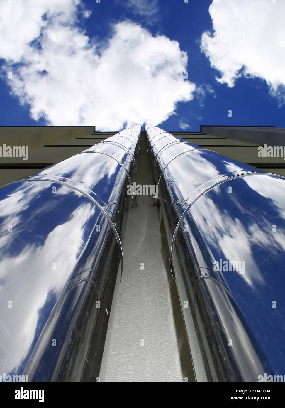 Two shiny steel pipes reaching up to blue sky, low angle view Stock ...