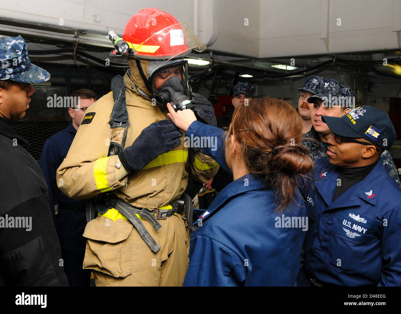 Sailors aboard a Navy vessel in Everett, Washington, practice donning ...