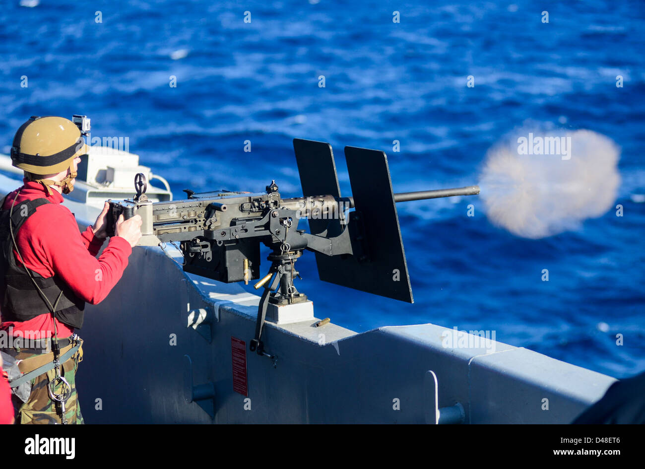 A Sailor aboard a U.S. Navy vessel fires a .50-caliber machine gun ...