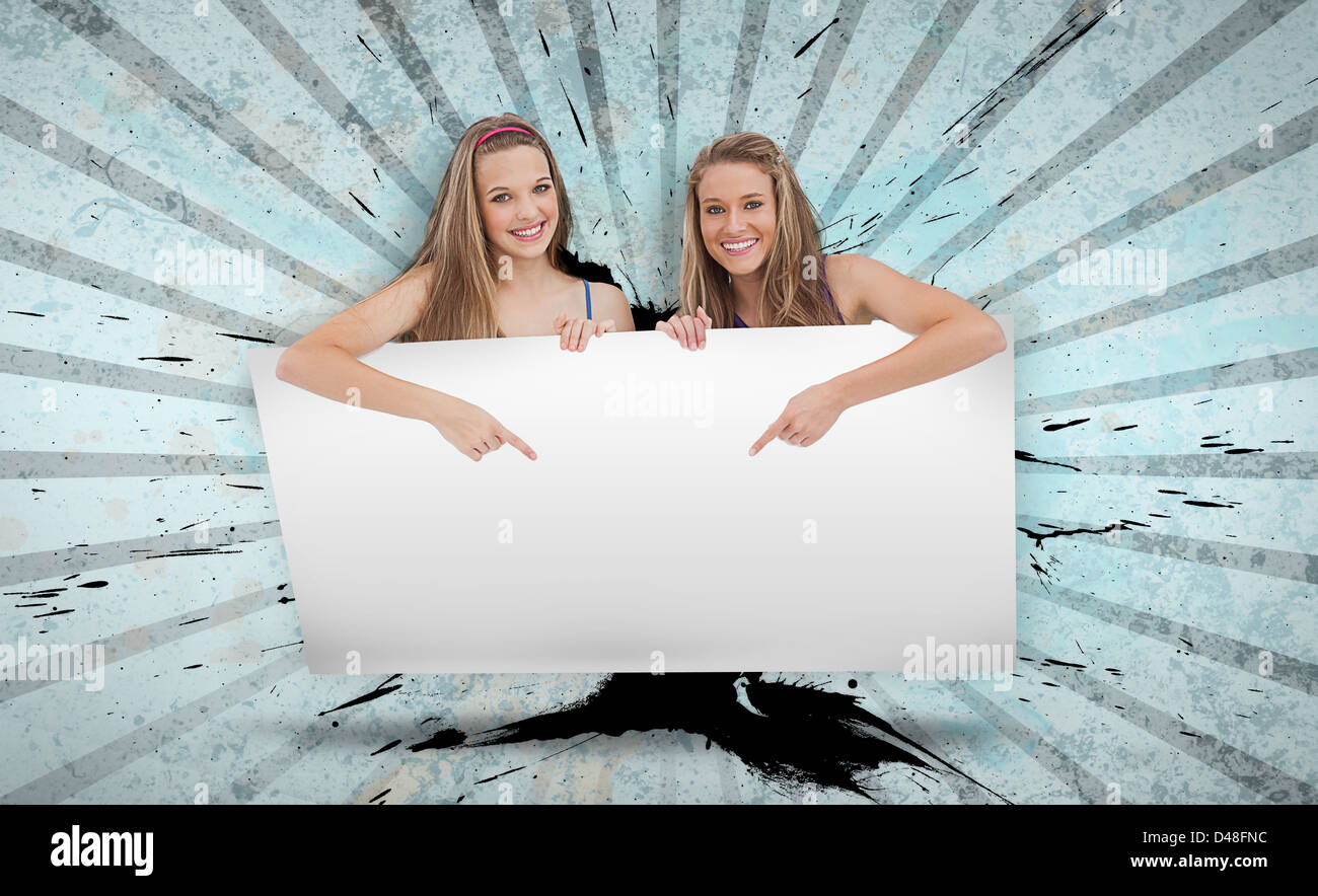 Pretty girls pointing to copy space card Stock Photo - Alamy
