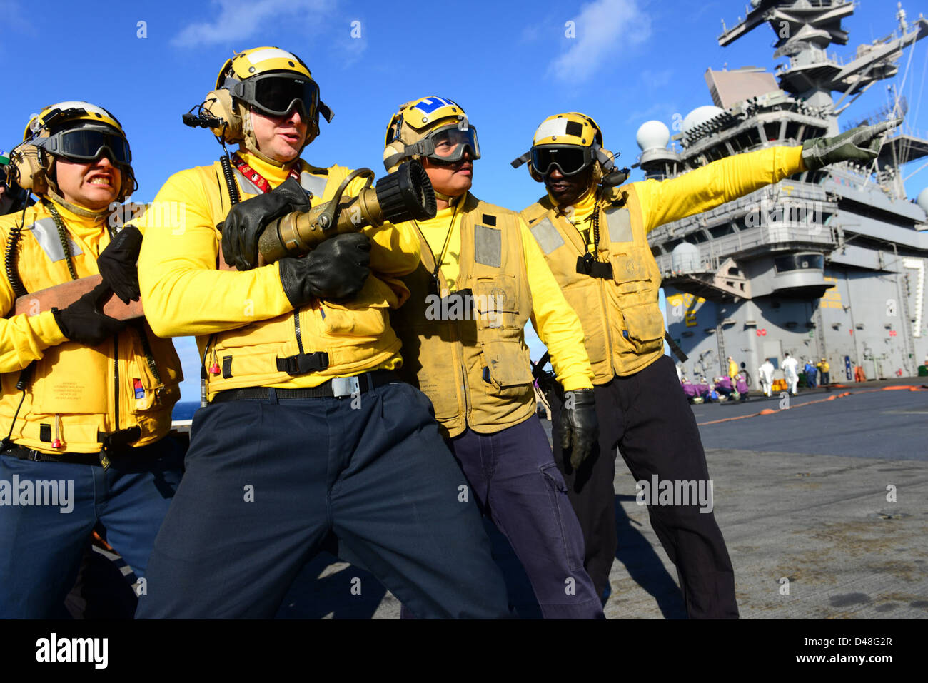 Sailors aboard a U.S. Navy vessel conduct fire fighting drills in the ...