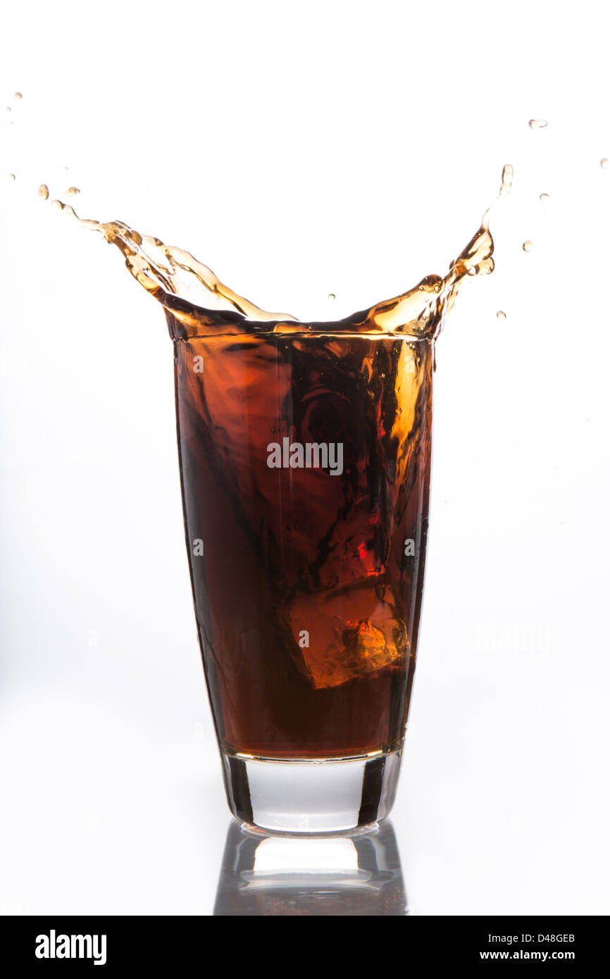 Ice cube falling into glass of soda Stock Photo - Alamy
